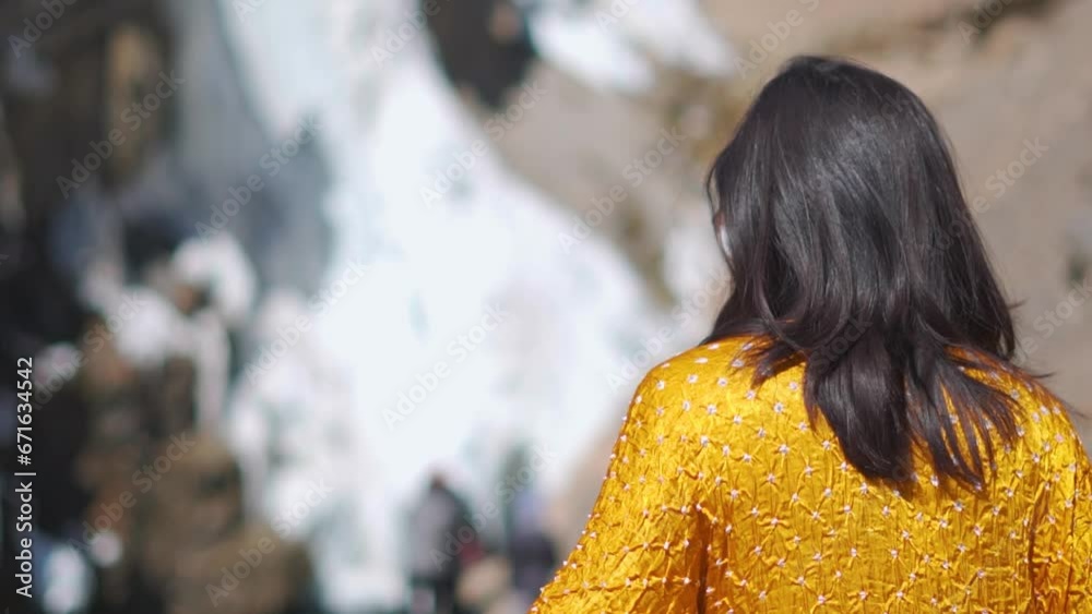 Tourist Indian woman wearing Indian clothes looking at frozen waterfall ...
