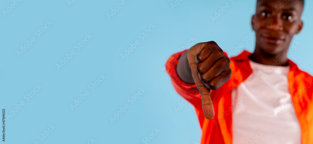 woman in orange shirt giving thumb down gesture, dislikes something ...