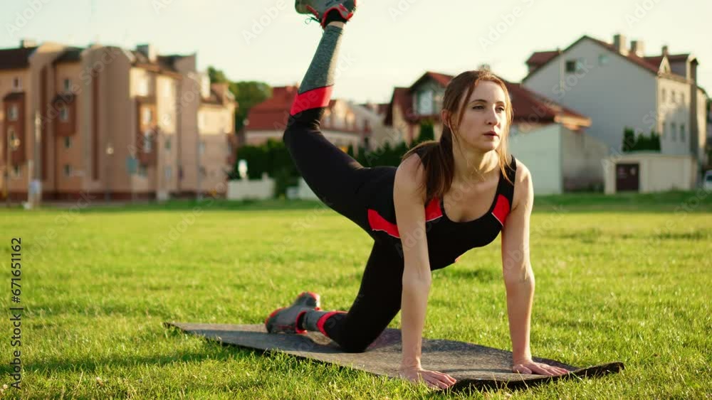 Fit young girl doing exercises on mat in urban area outdoors at ...