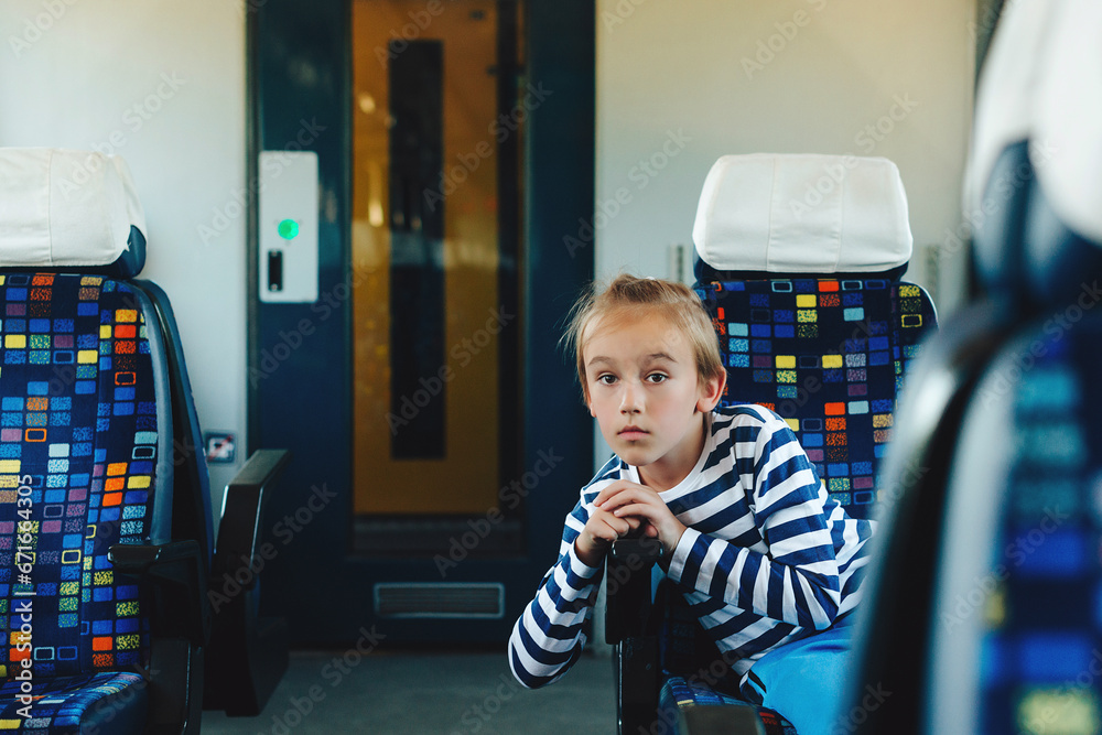 Cute boy sitting in commuter electric train. Little kid traveling on ...