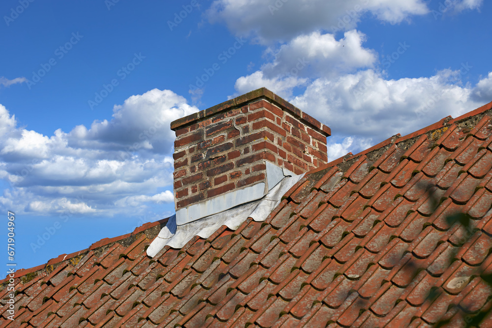 Red brick chimney designed on slate roof of house building outside ...