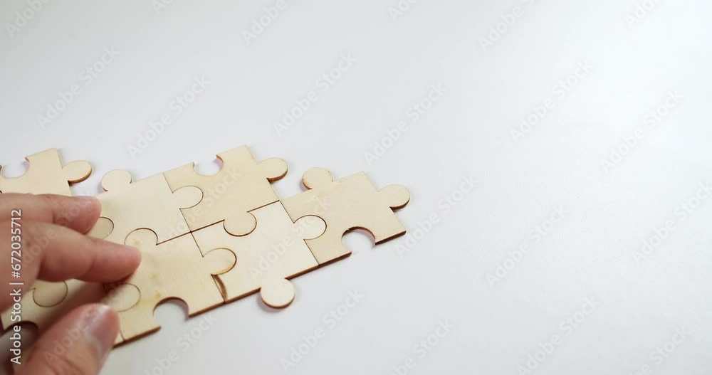 Vidéo Stock Arranging the pieces of a jigsaw puzzle one-by-one on a ...