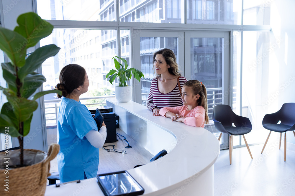 Happy diverse daughter patient and mother talking with female doctor at ...