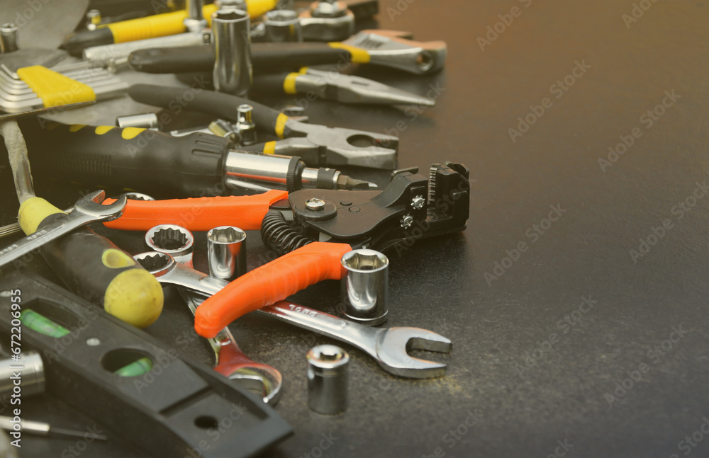 Handyman tool kit on black wooden table. Many wrenches and screwdrivers ...