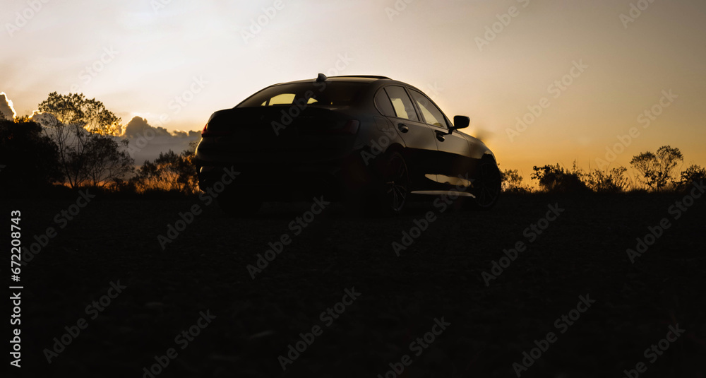 BMW 3 series rear end silhouette against susnet sky, sports car ...