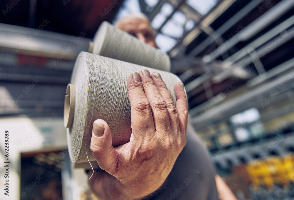 Hand carrying cotton rolls in a weaving factory, machine weaving cotton ...