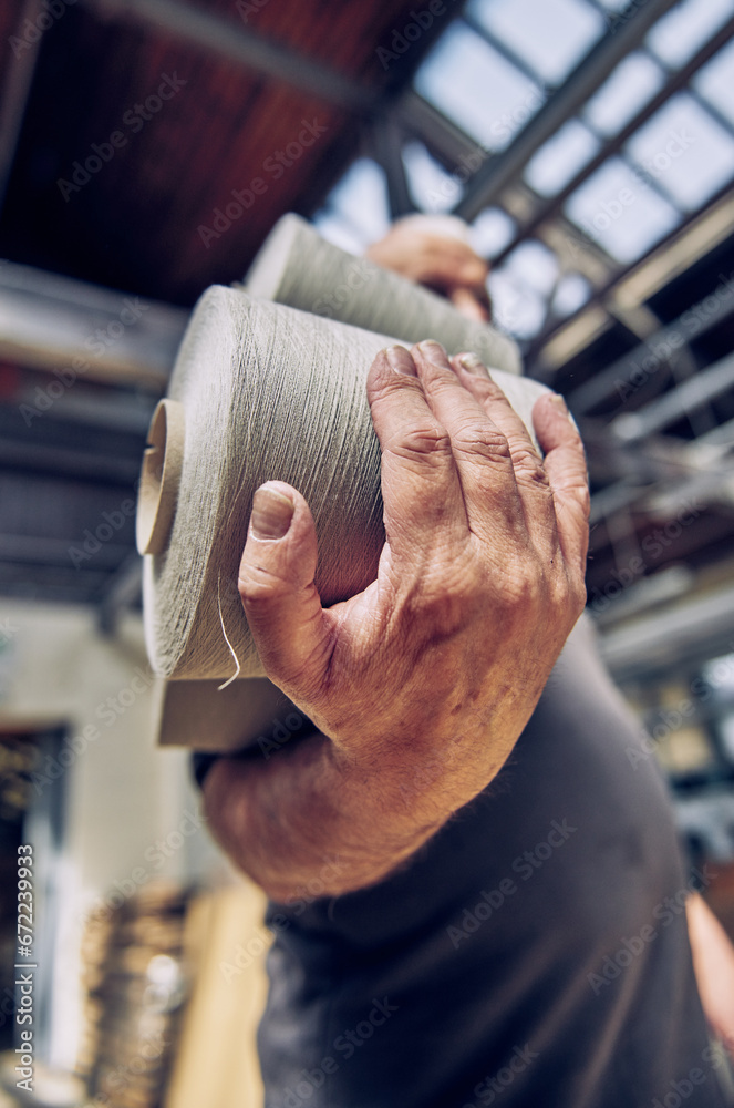 Hand carrying cotton rolls in a weaving factory, machine weaving cotton ...