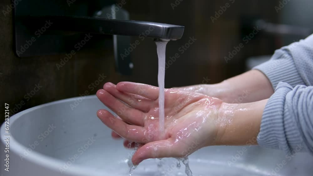 Close up of biracial woman washing hands in bathroom, slow motion. Self ...