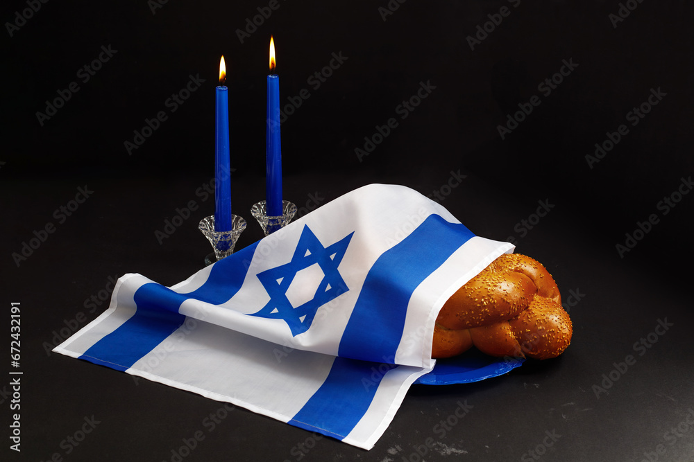 Challah bread covered with the Israeli flag, burning blue candles ...