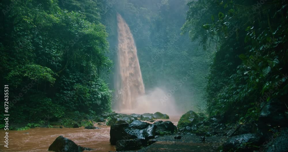Tropical nature Nungnung waterfall among dense greenery in mountain ...
