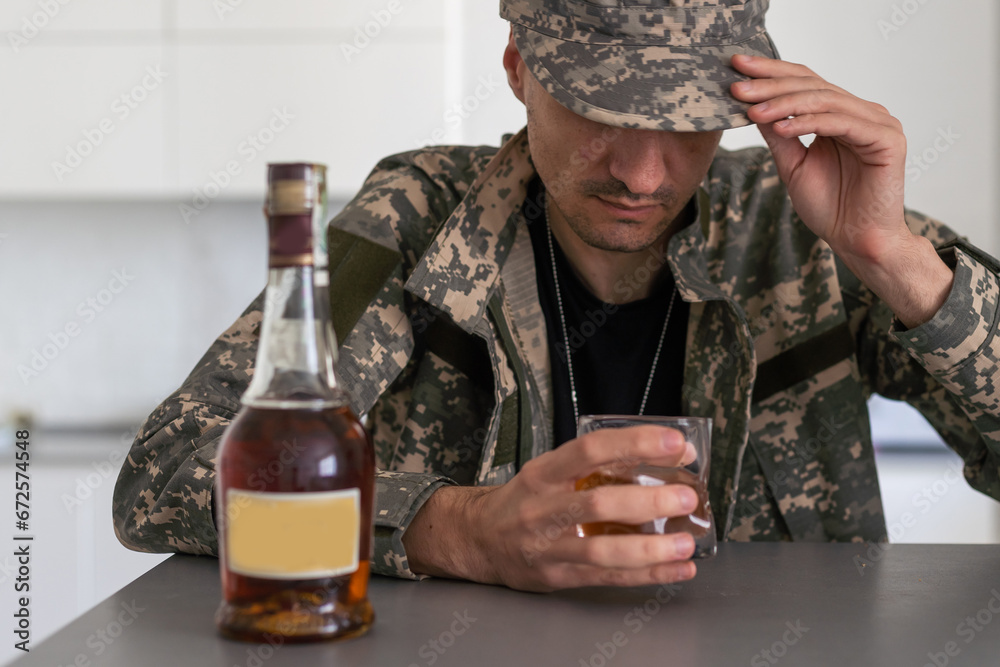 Upset young man drinker alcoholic sitting at bar counter with glass drinking whiskey alone, sad ...