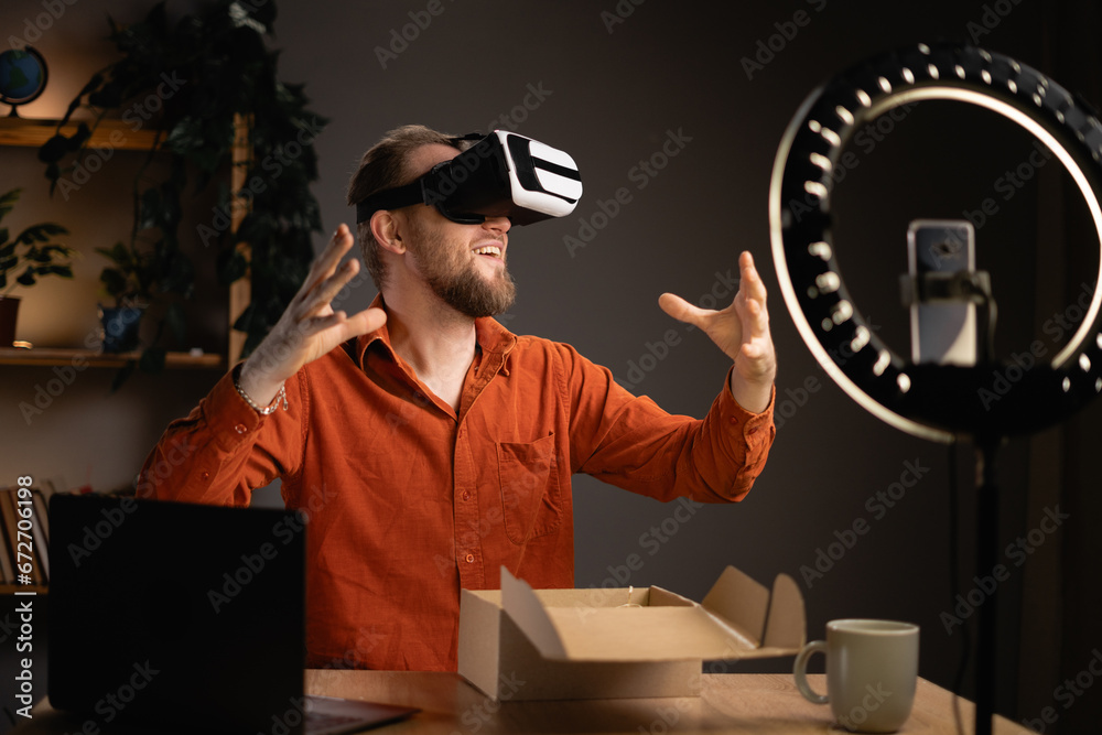 Handsome tech blogger male influencer unboxing device using modern ...