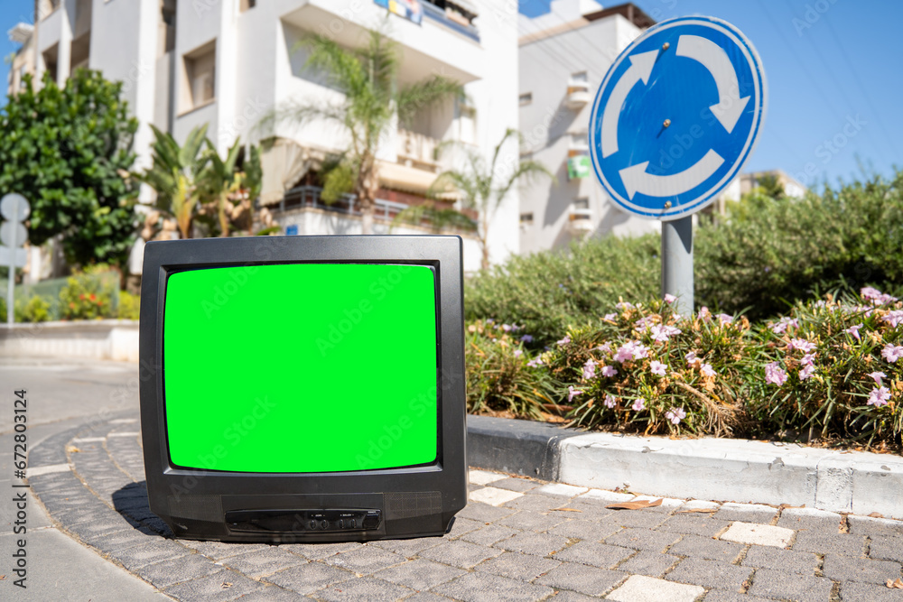 Old black TV set stands on the street paving stones next to the ...