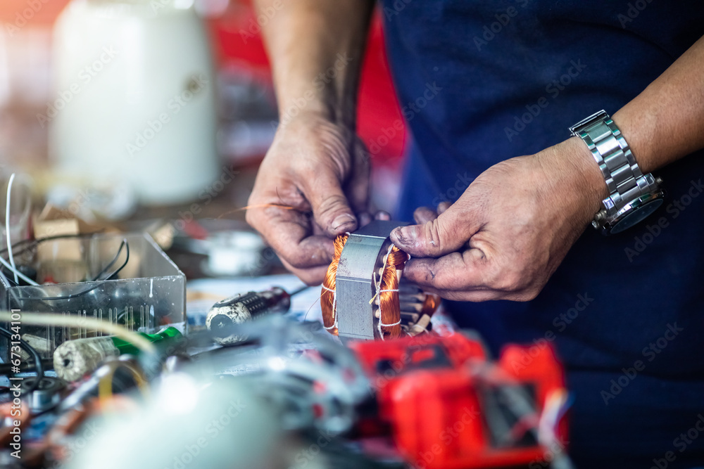 Selective focus to hand of an electric motor repairman. Mechanic is ...