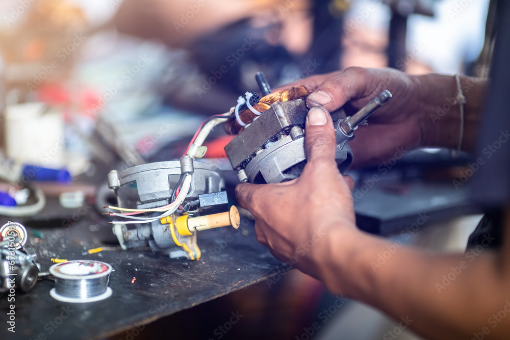 Selective focus to hand of an electric motor repairman. Mechanic is ...
