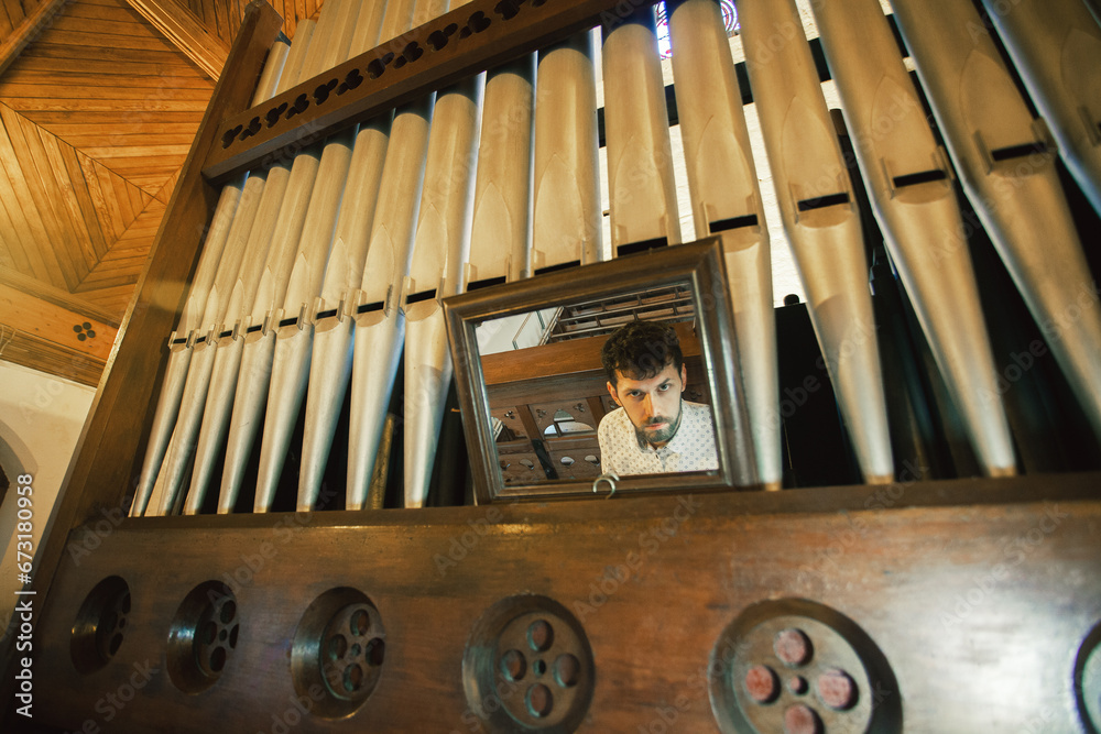 Artistic portrait of young handsome man playing the old organ in Irish ...