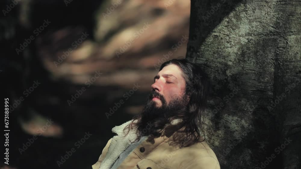 Jesus Christ. Bearded man sleeping and meditating, leaning against a ...