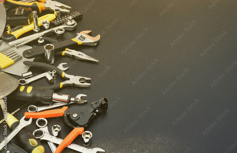Handyman tool kit on black wooden table. Many wrenches and screwdrivers ...