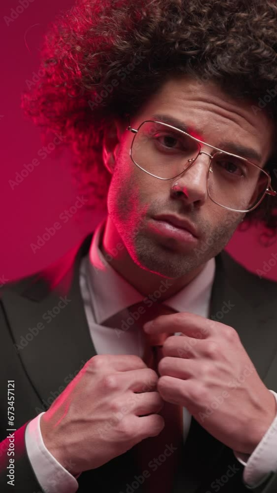 attractive high class man with glasses looking to side and adjusting ...