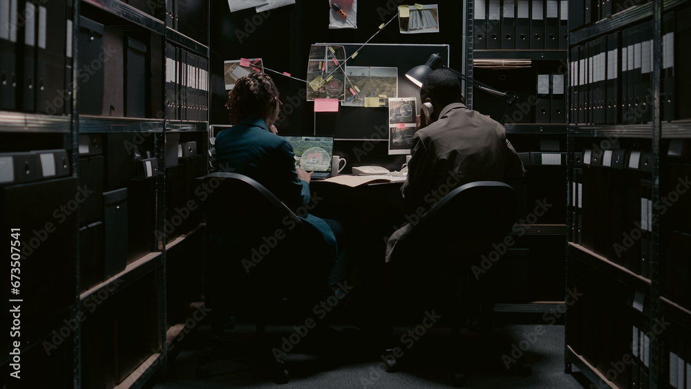 Foto de African american agents examining surveillance photos, working ...