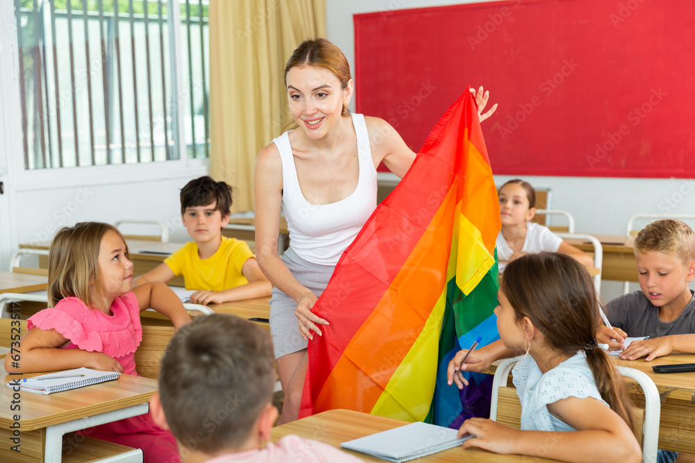 Positive female teacher standing with lgbt flag, supporting diversity ...