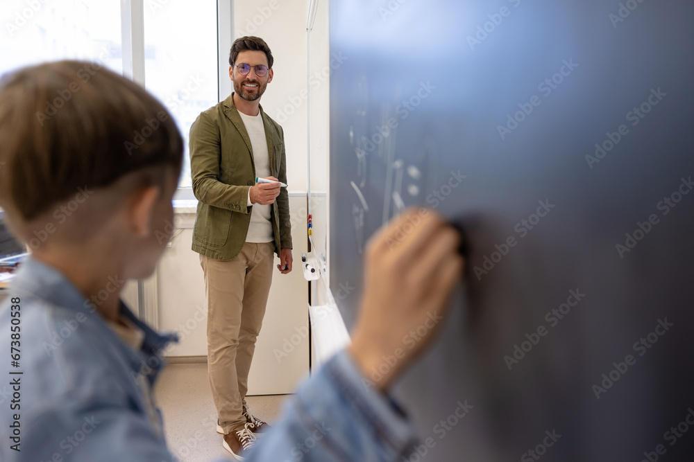 The boy answering at the maths lesson and writing on the board Stock ...