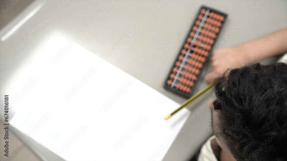 little kid solving math problems using mental arithmetic and paper in a ...