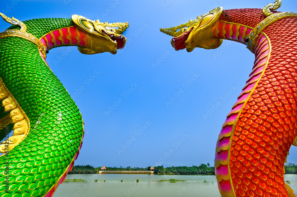 Green and red Naga statue with Bang Pakong River in the background ...