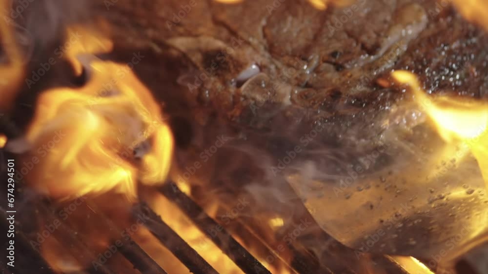 Roast beef with fire flames. Beef steak on grill with flames. Rib-eye ...