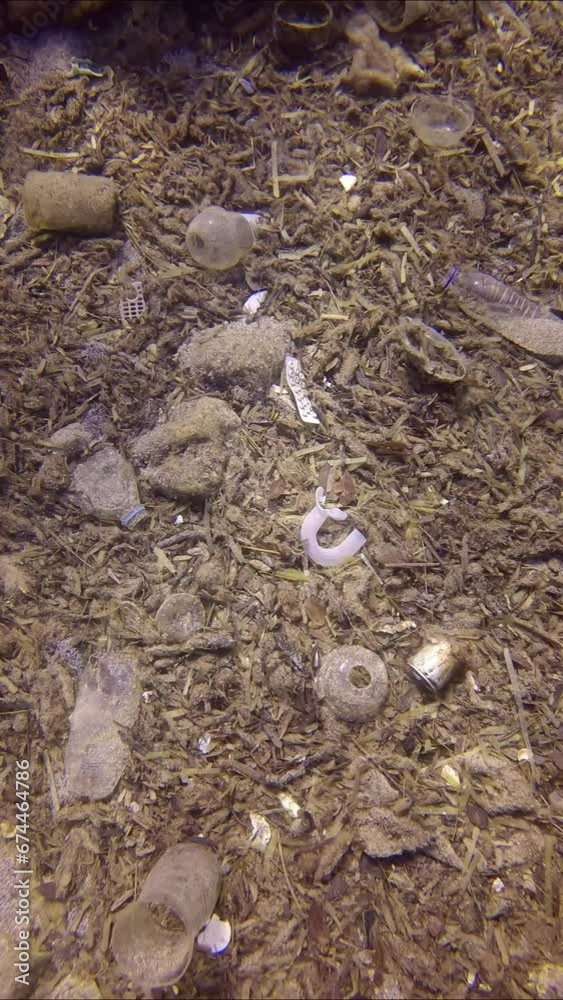 Vertical video, Top view, Lots of plastic debris at sea bed of ...