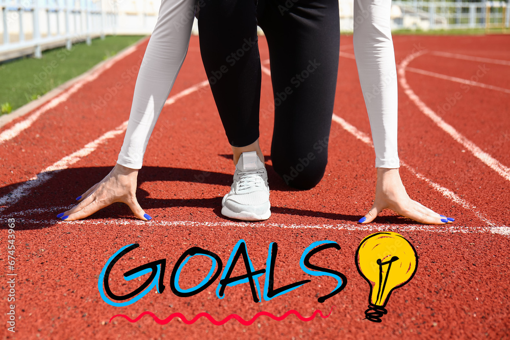 Woman in crouch start position at the stadium. Concept of new goals ...