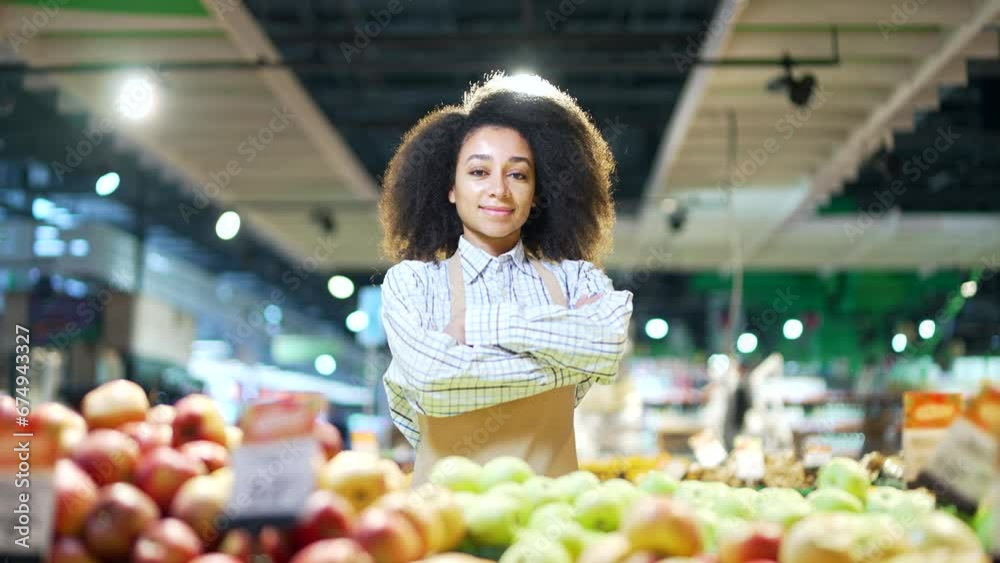 Portrait of a saleswoman female worker in a supermarket looking at ...