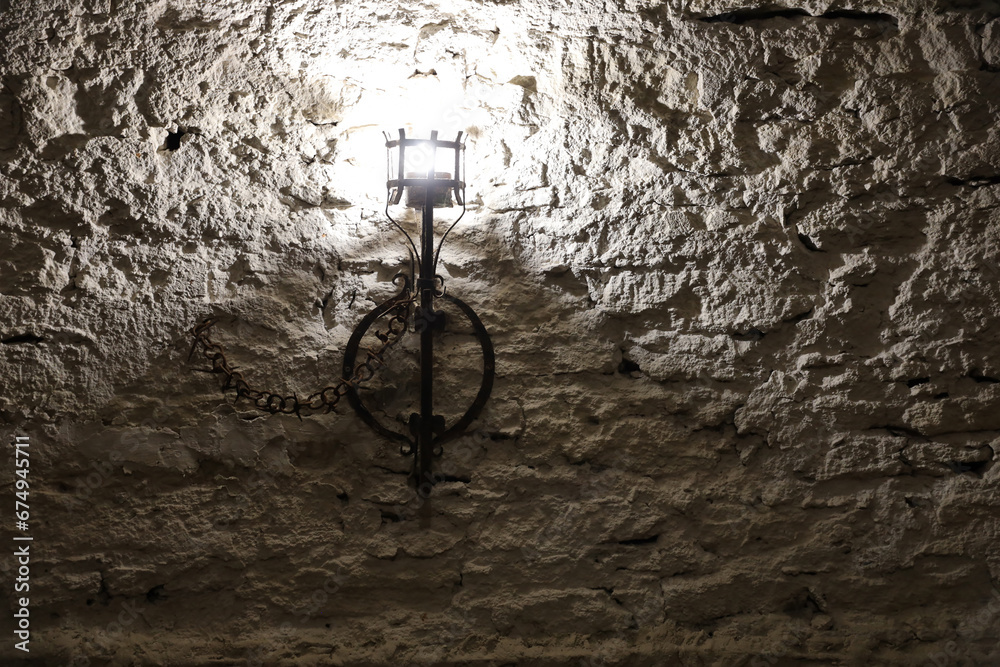 Lighted medieval castle torch hanging on a stone wall, vintage objects ...