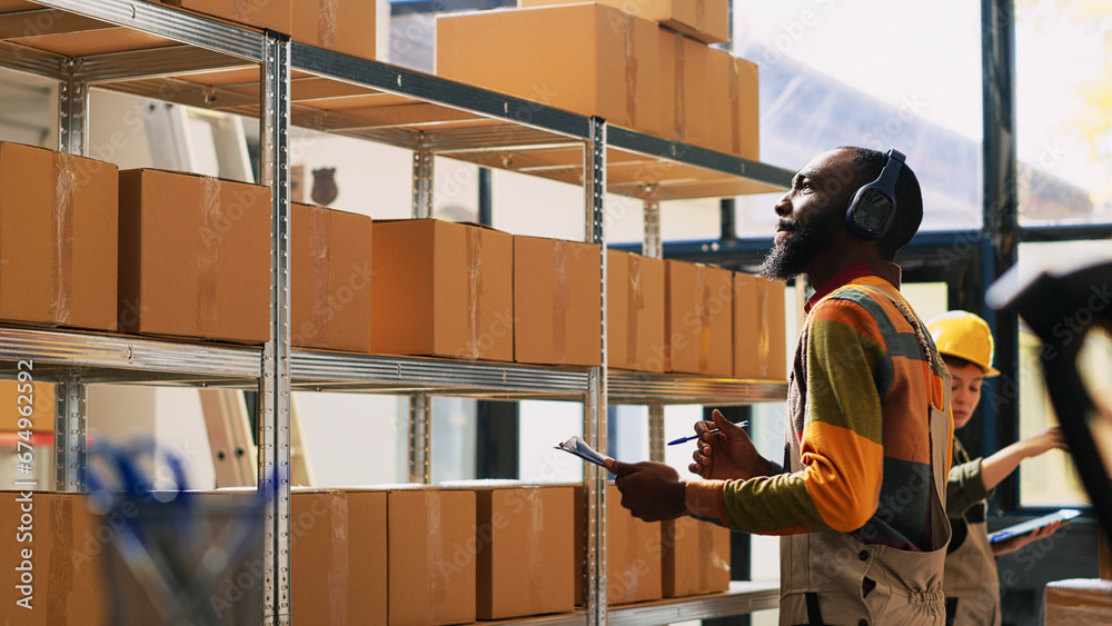Supervisor inspecting stock logistics with inventory list, looking at ...