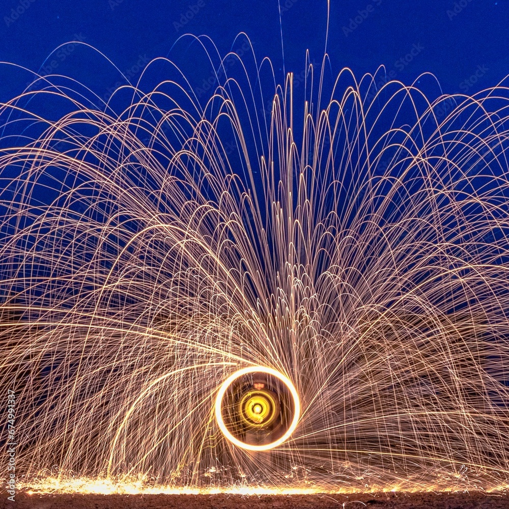 Man radiating fireworks from a center of an iron wool circle against a ...