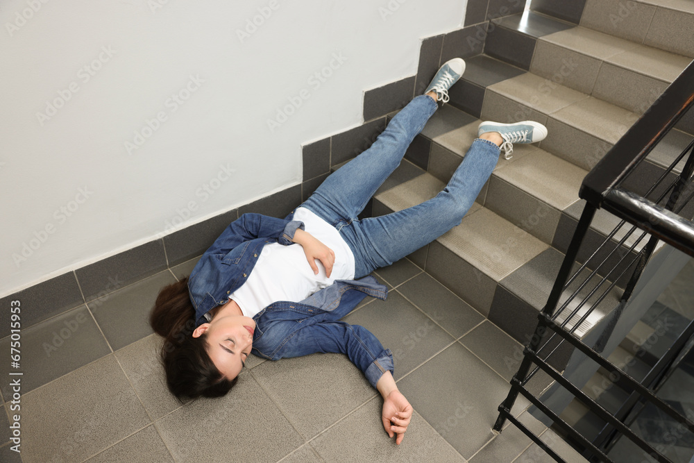 Unconscious woman lying on floor after falling down stairs indoors ...