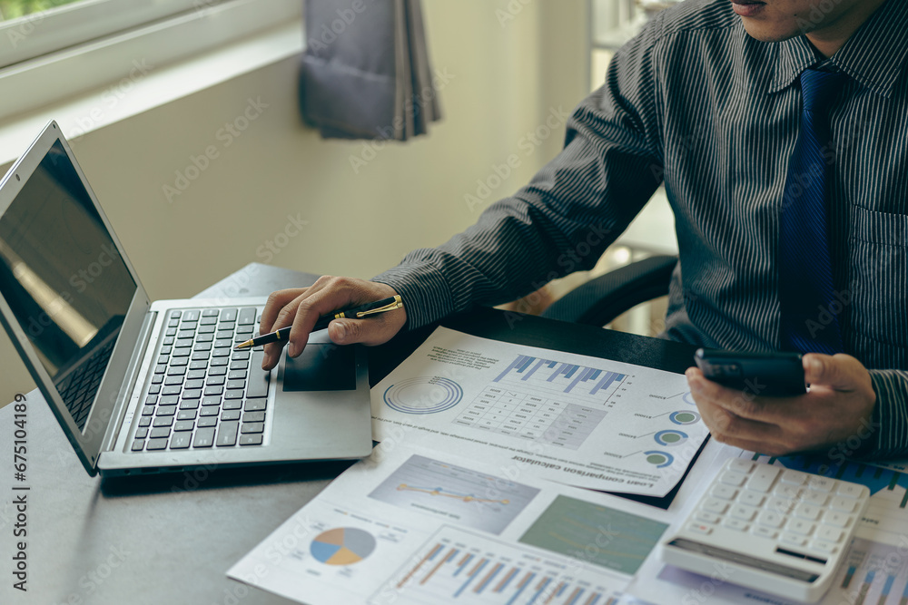 Young Asian businessman working with laptop, checking graphs, company ...