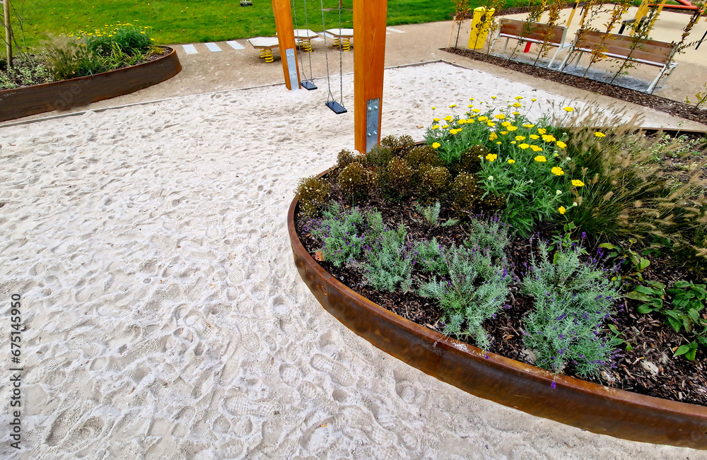 the oval ellipse of the flower bed is lined with a rusty sheet metal ...