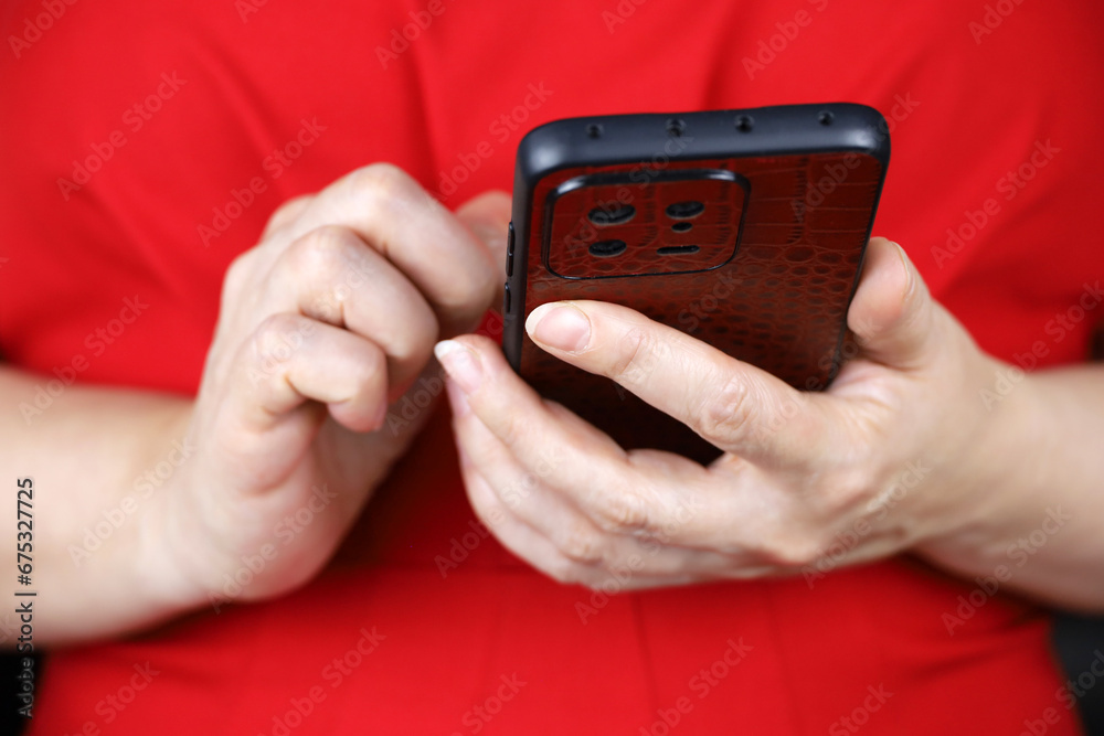 Woman in red dress using smartphone, mobile phone in female hands close ...