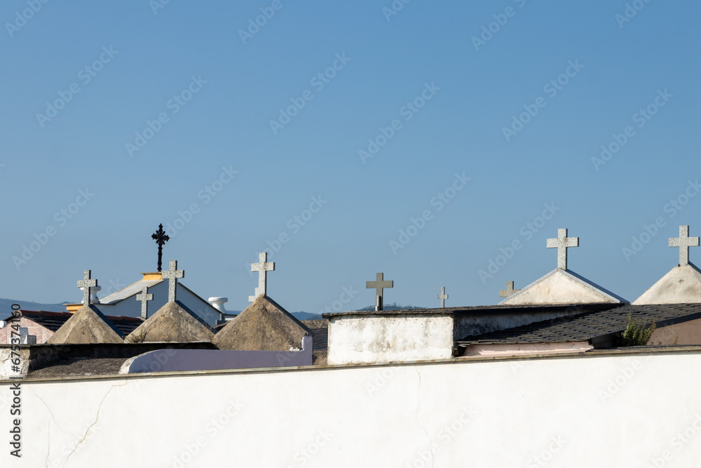 row of different sized and styled stone crosses on top of a white wall ...