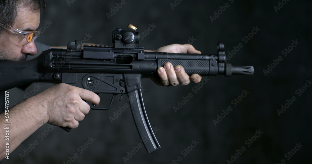 Firing weapon in high-speed, HK SP5K GUN side view. Person aiming and ...