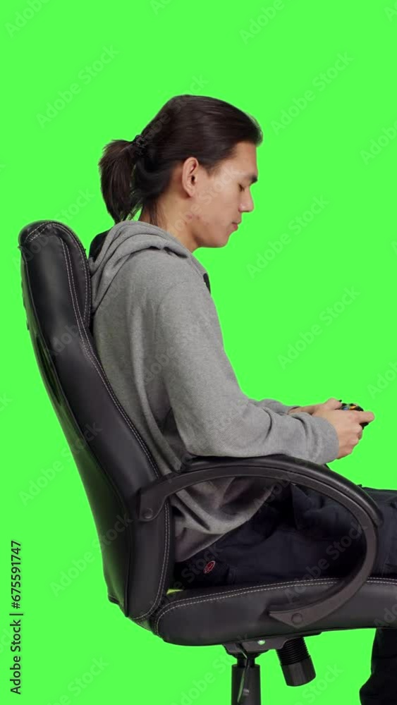 Profile of asian gamer playing video games over greenscreen background ...