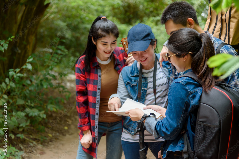 Group of friends walking on an adventure in the forest Look at the map ...