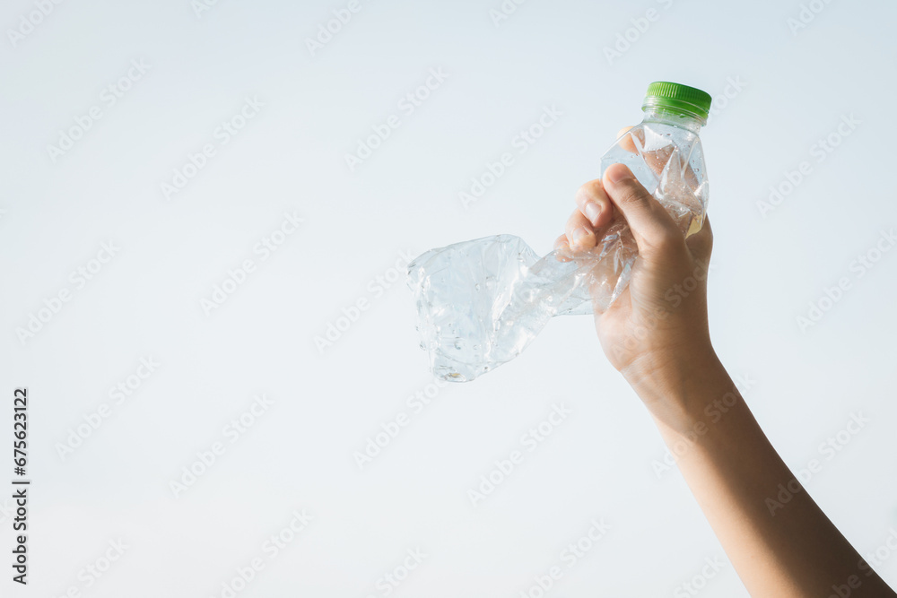 Recyclable plastic bottle held in hand up on sky background. Hand ...