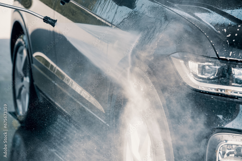 Car washing with a high pressure water jet at an outdoor self-service ...