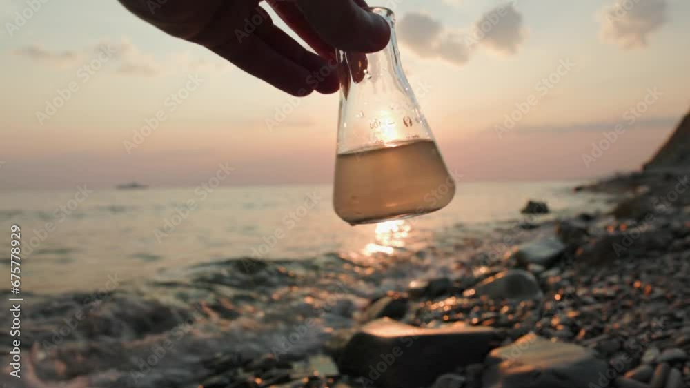 Close up of glass test sample flask of dirty water examines by ...