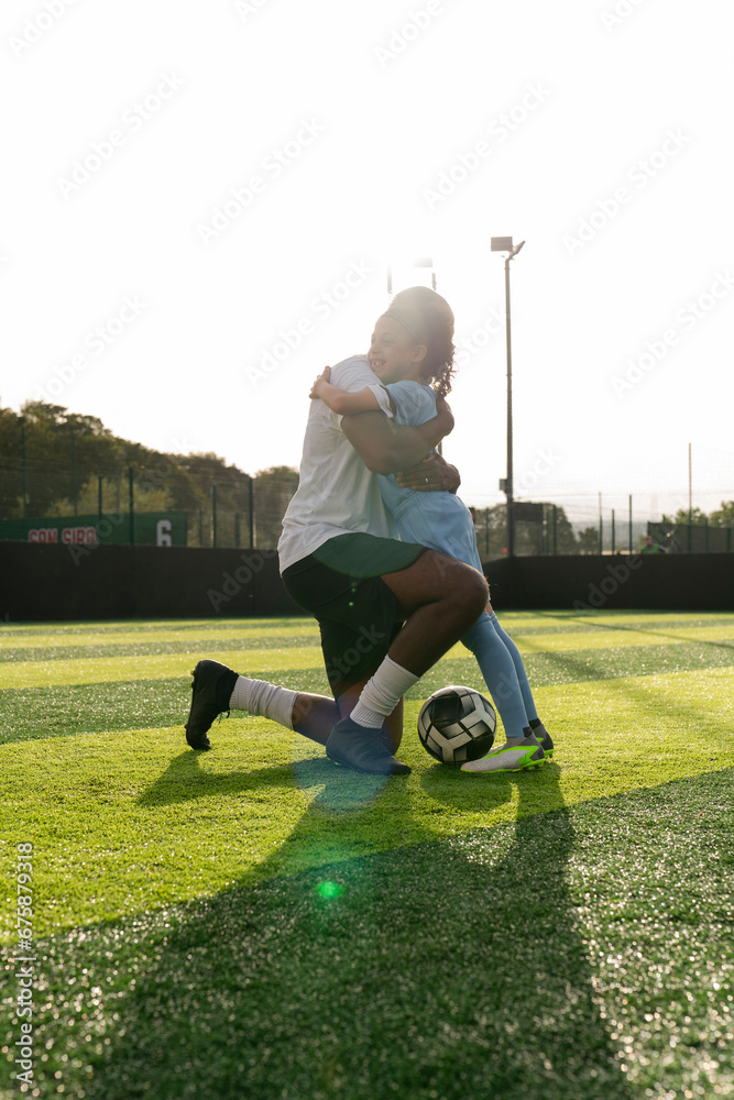 Coach and girl (6-7) hugging on soccer field Stock Photo | Adobe Stock