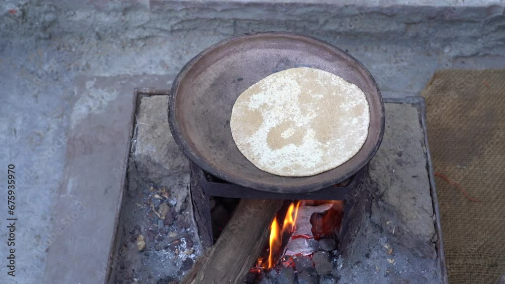 Making roti or Indian Chapati on roti tawa made of wheat with hand ...