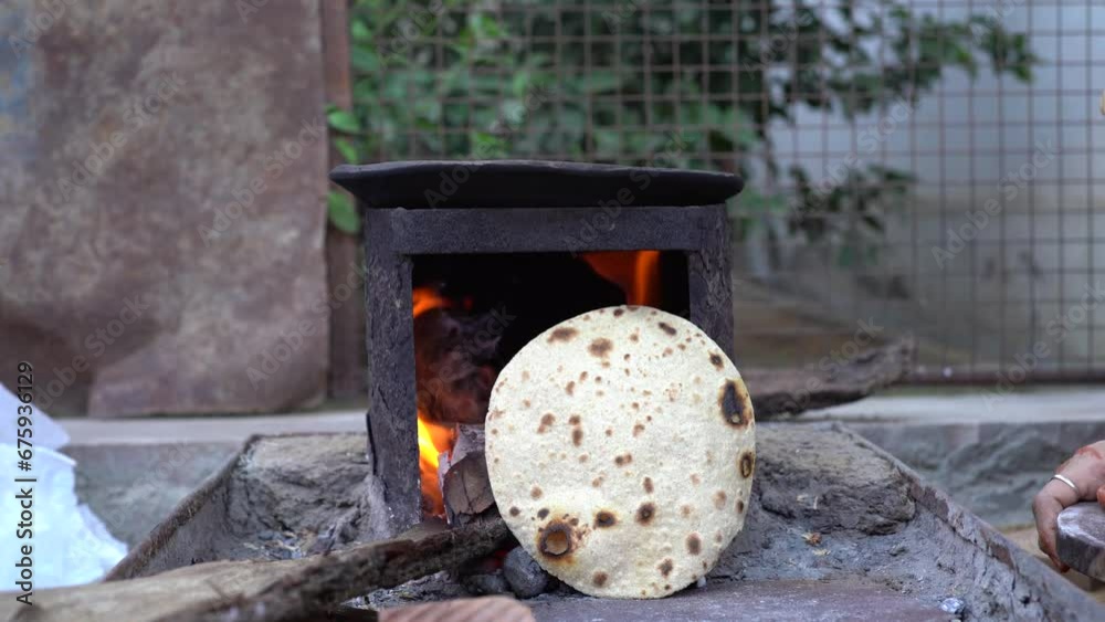 Making roti or Indian Chapati on roti tawa made of wheat with hand ...