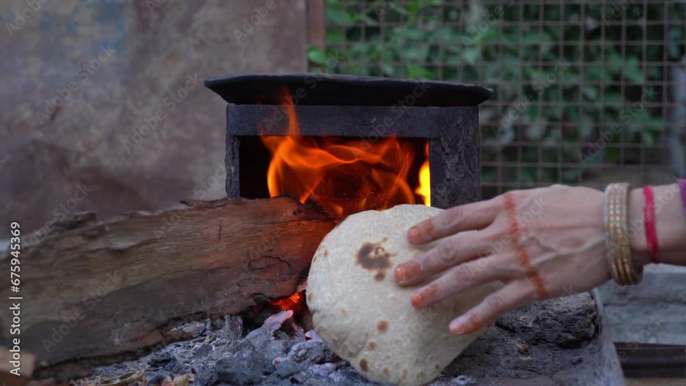 Making roti or Indian Chapati on roti tawa made of wheat with hand ...